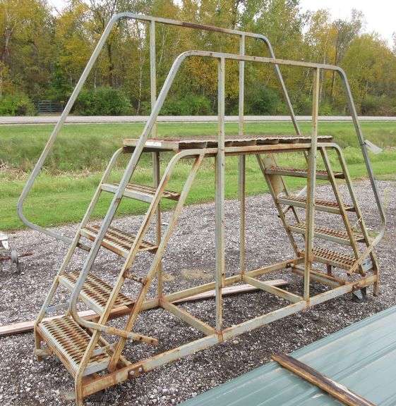 Rolling double staircase work platform, has wheels on all 4 corners ...
