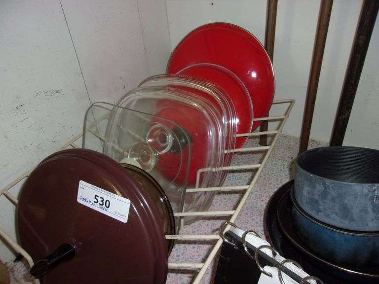 CONTENTS OF SHELF: PYREX & METAL LIDS W/ MIXED SIZED POTS & PANS ...