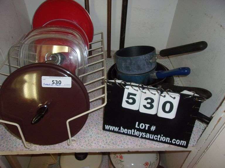 CONTENTS OF SHELF: PYREX & METAL LIDS W/ MIXED SIZED POTS & PANS ...