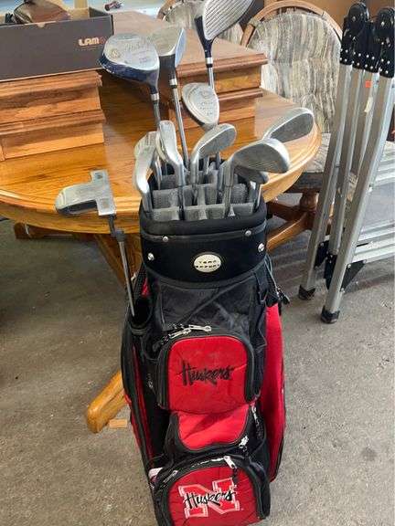 SET OF JOHN DALY GOLF CLUBS IN A HUSKER BAG - Isabell Auction