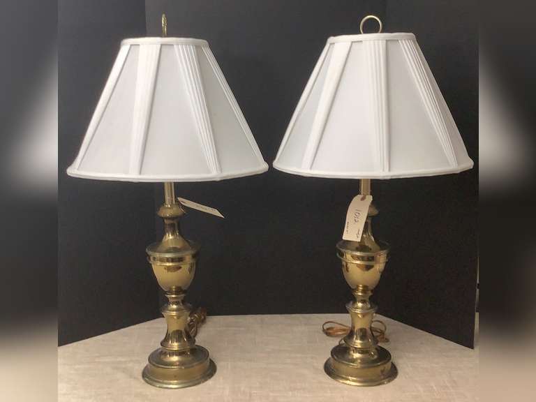 One pair of brass table lamps, 32 inches tall. One of the shades has ...