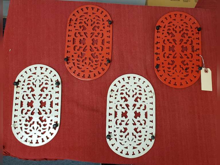 4 Red and white cast iron trivets