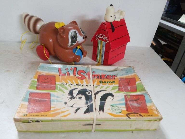 Lil Stinker Game, Racoon Pull Behind Toy, Snoopy Books - Trice Auctions